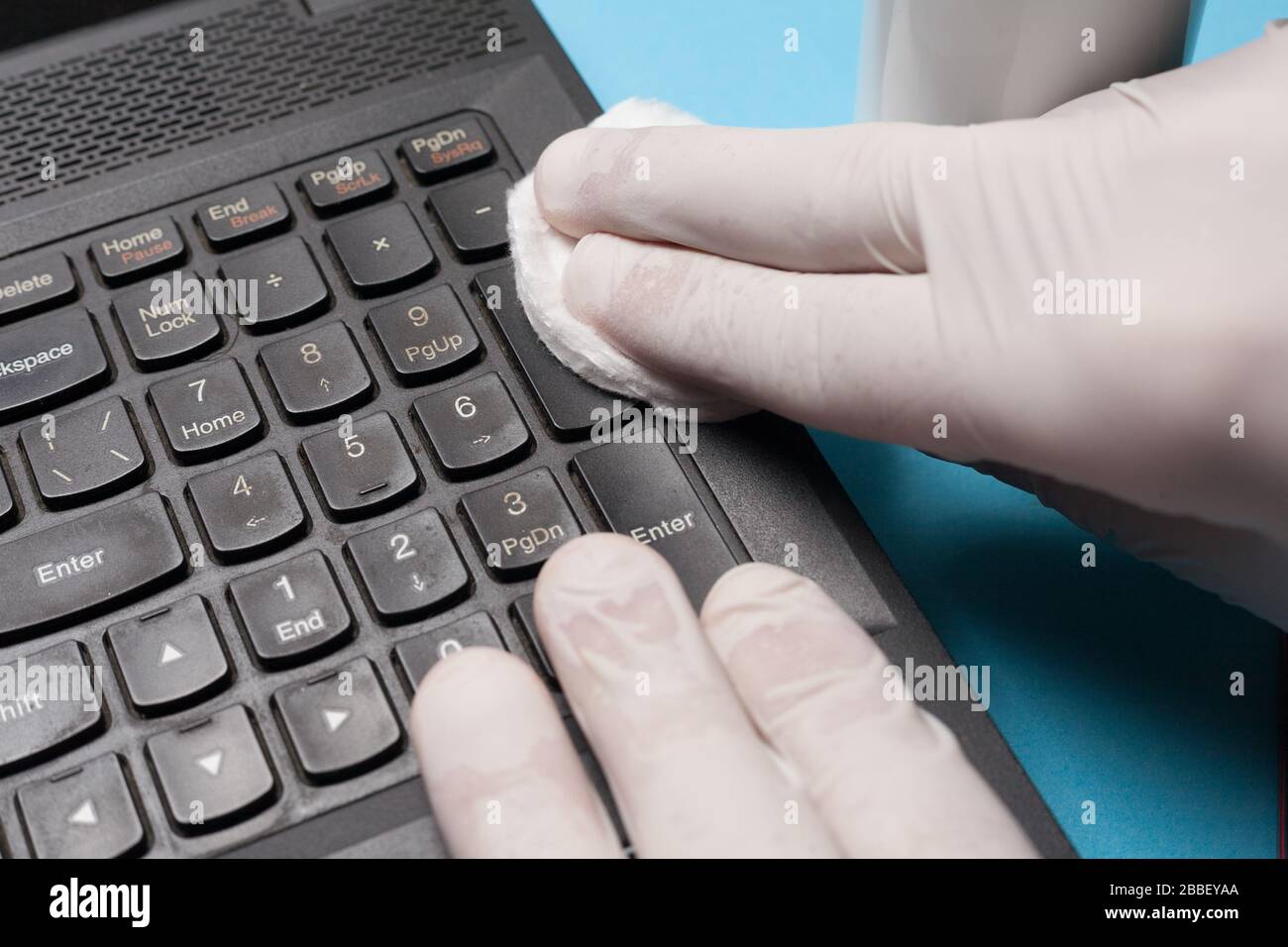 Close-up of disinfection cleaning a laptop in white gloves. Prevention ...