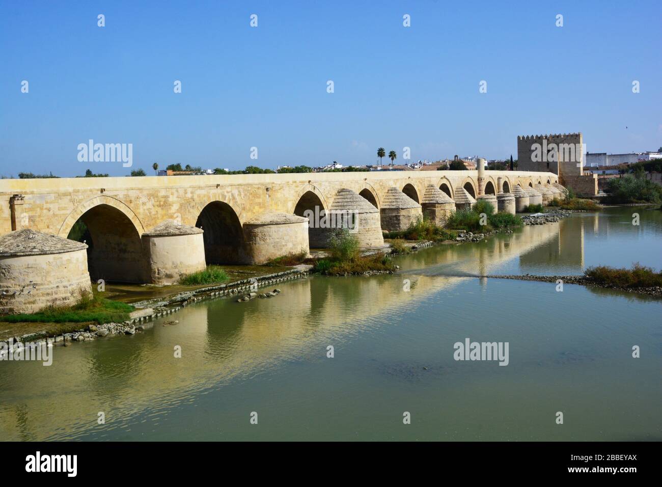Cordoba, Spain: panoramic view of long, restored bridge with many ...