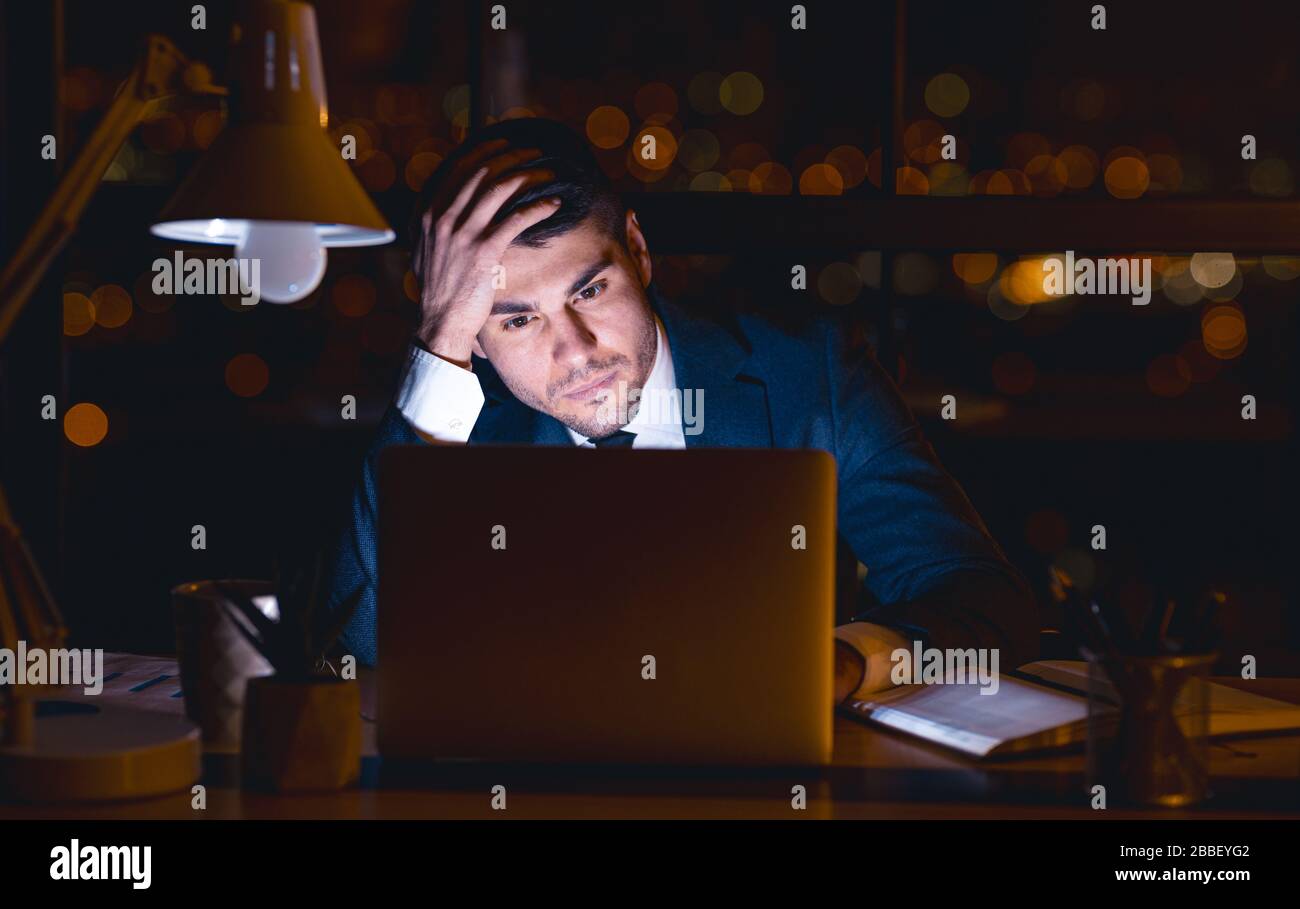 Entrepreneur At Laptop Thinking Touching Head Sitting Overnight In ...