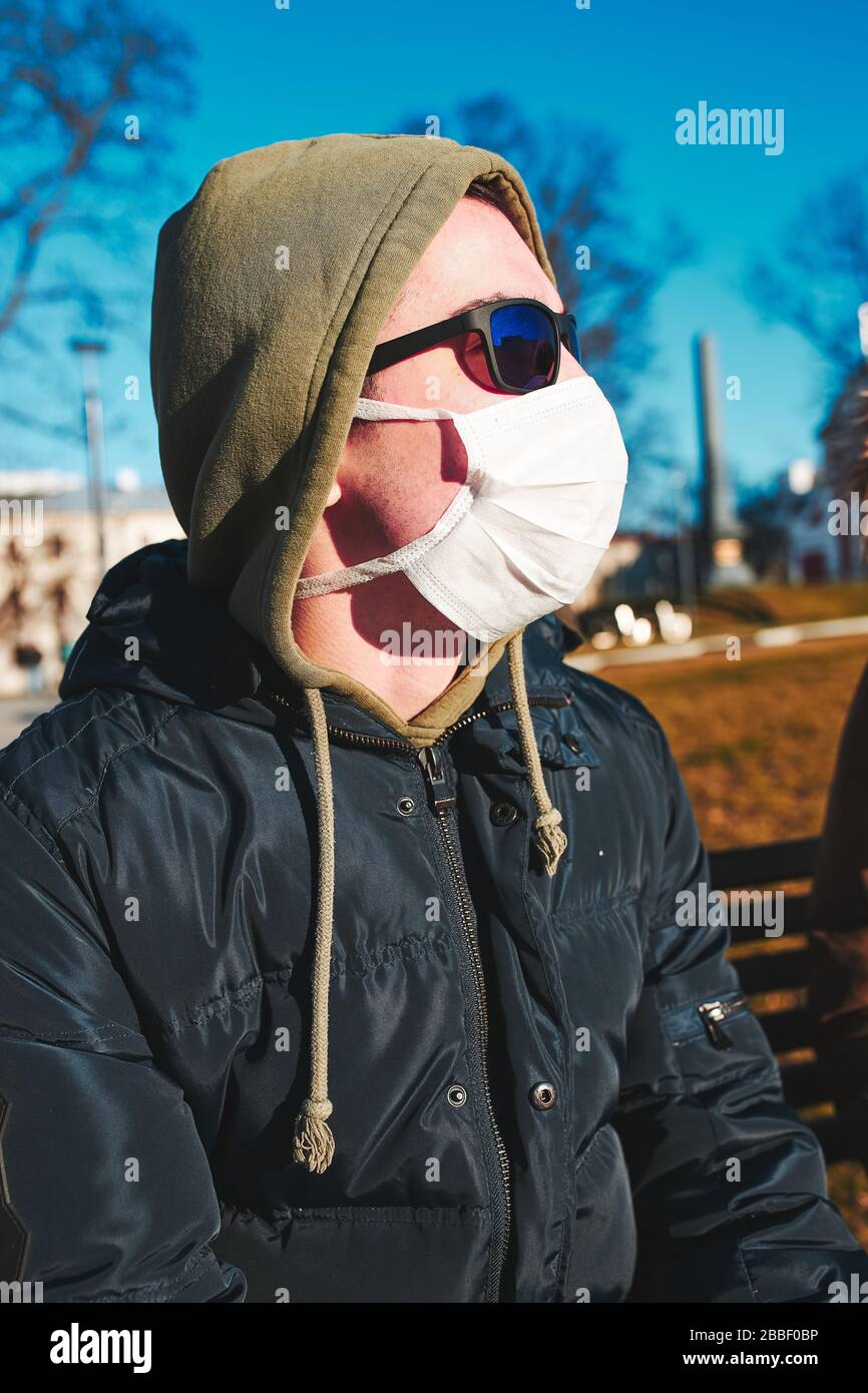 Young man in the hood wearing the face mask to avoid virus infection ...