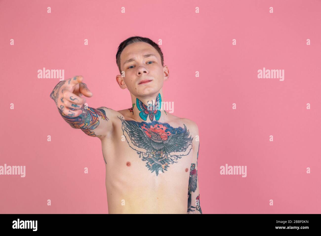 Pointing. Portrait of young man with freaky appearance on pink ...
