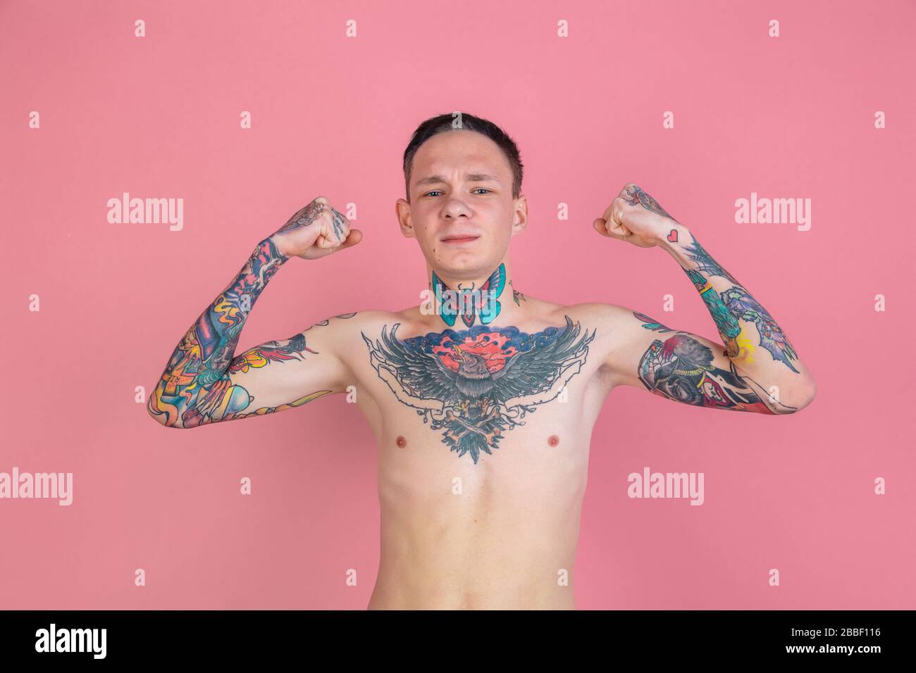 Strong gesture. Portrait of young man with freaky appearance on pink ...