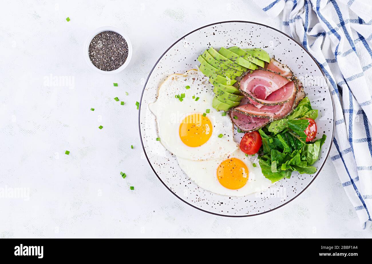 Ketogenic/paleo diet. Fried eggs, ham, avocado and fresh salad. Keto ...