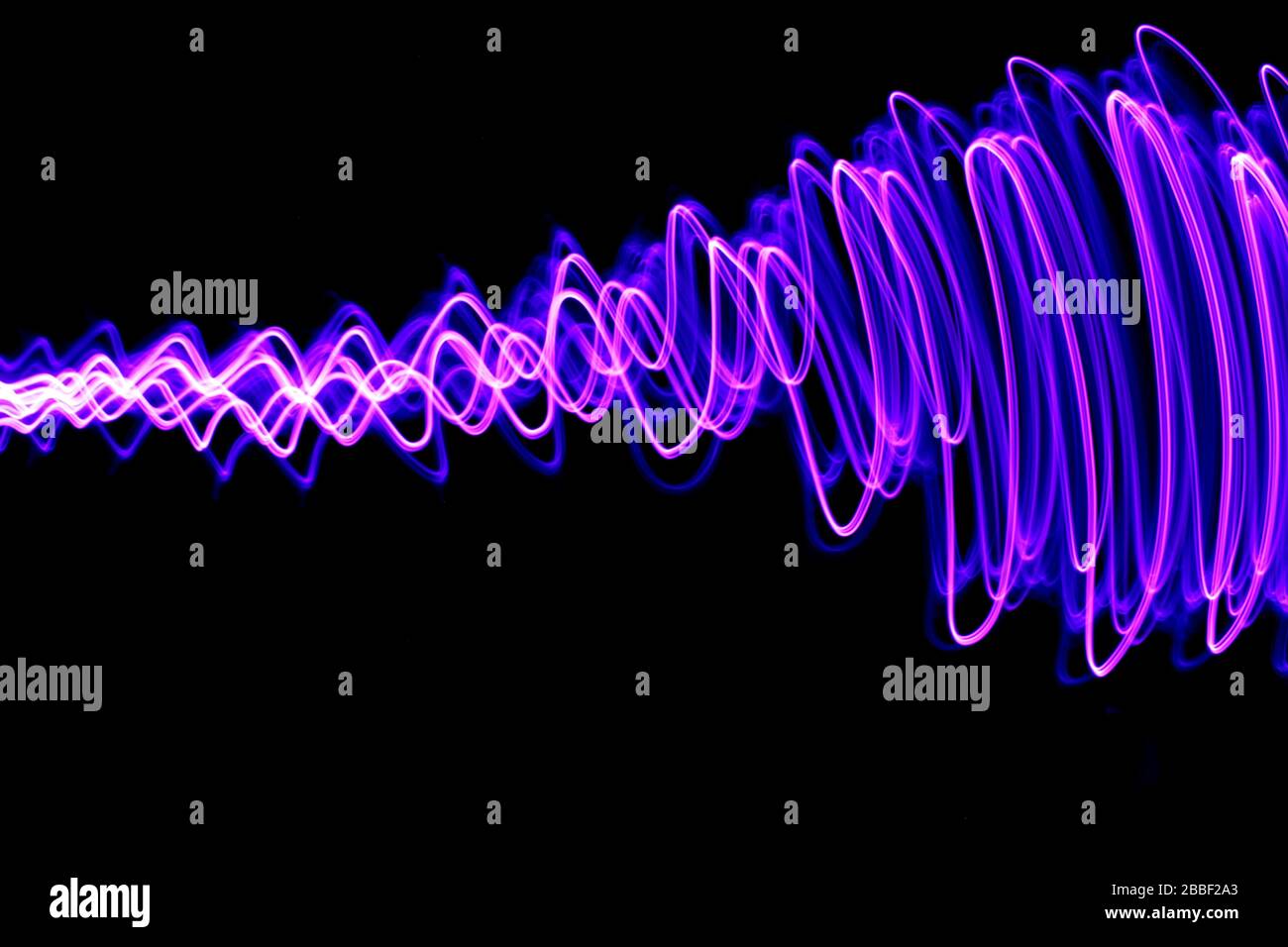 Long exposure photograph of vibrant neon color in an abstract swirl ...