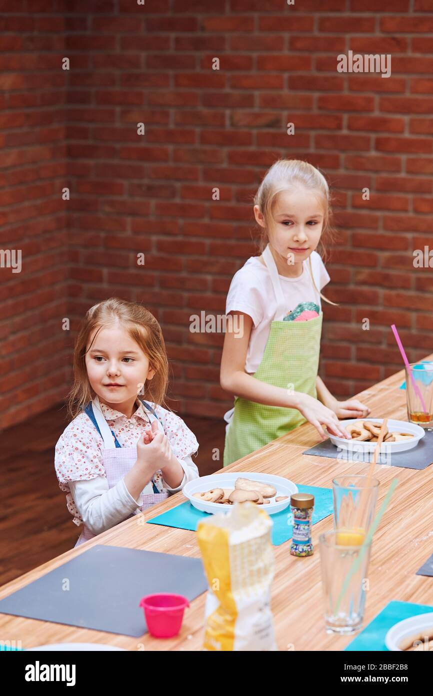 Girls preparing for decorating baked cookies. Kids taking part in ...