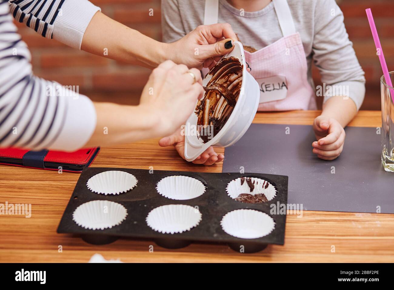 Little girl and her mom putting the melted chocolate and cocoa to ...