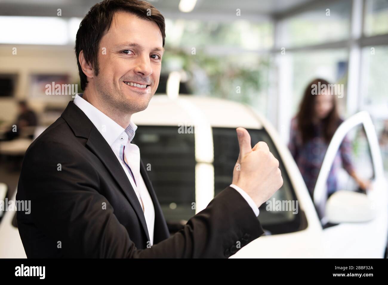 Car salesman shows a customer a new car Stock Photo - Alamy