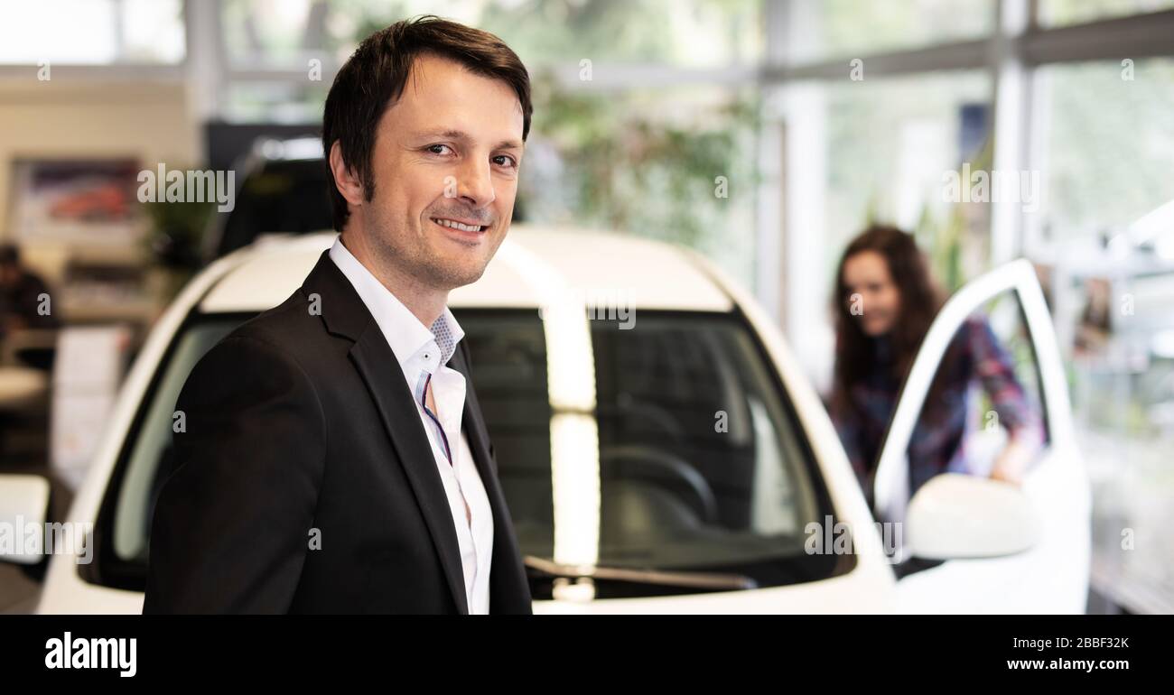 Car salesman shows a customer a new car Stock Photo - Alamy