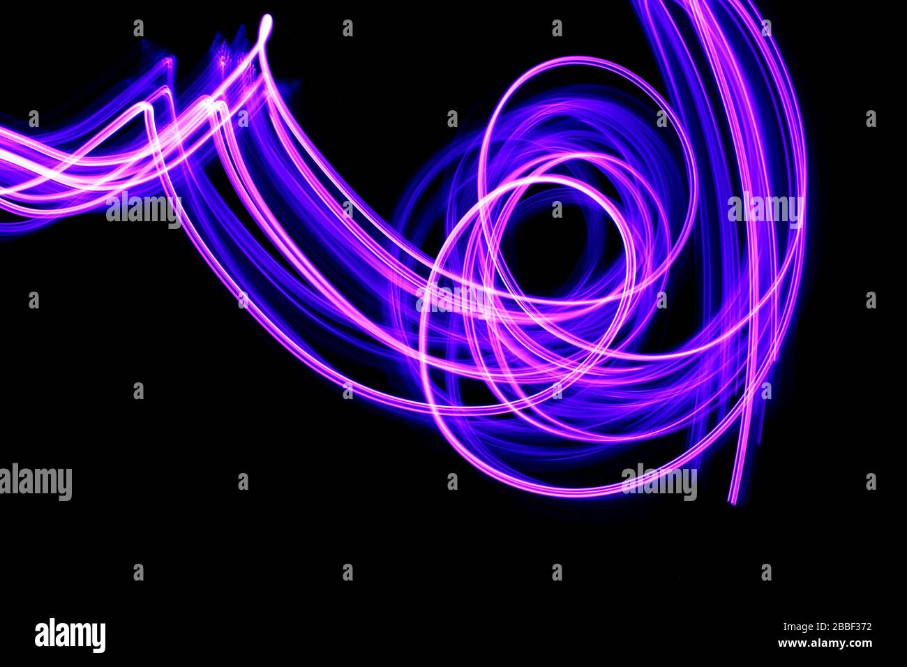 Long exposure photograph of vibrant neon color in an abstract swirl ...