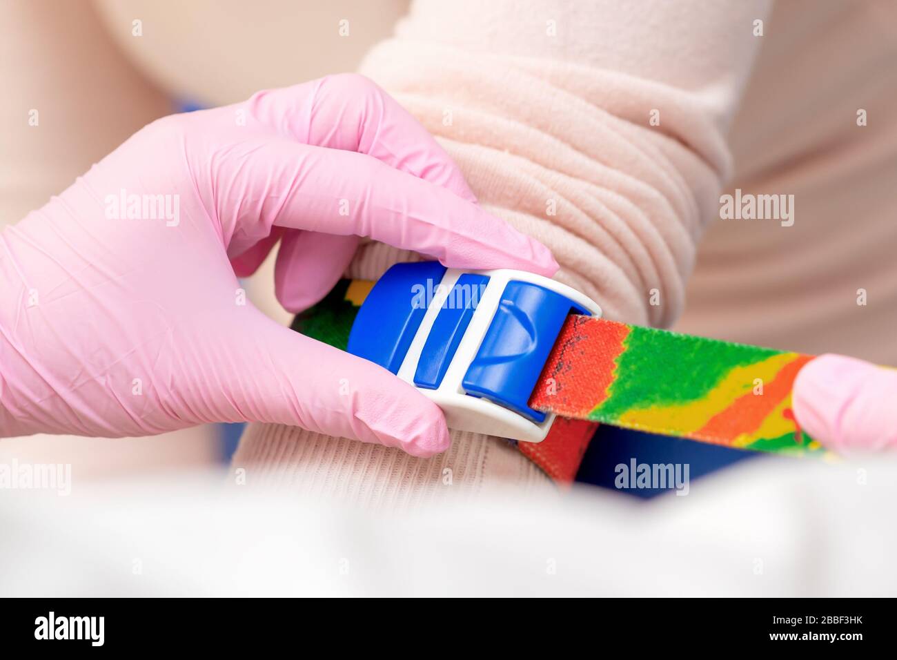 Nurse tightens the harness on the arm to take blood from a vein for ...