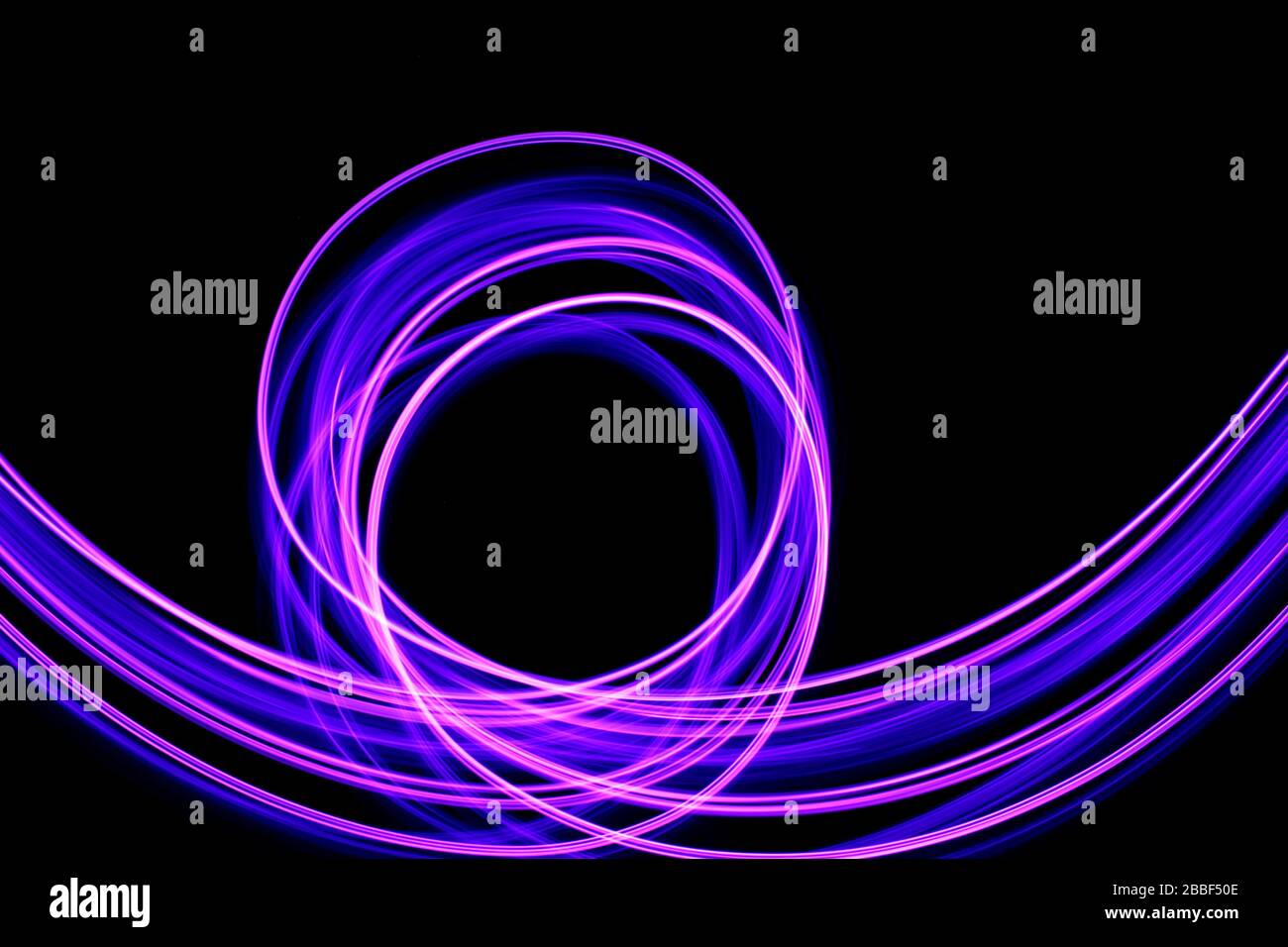 Long exposure photograph of vibrant neon color in an abstract swirl ...