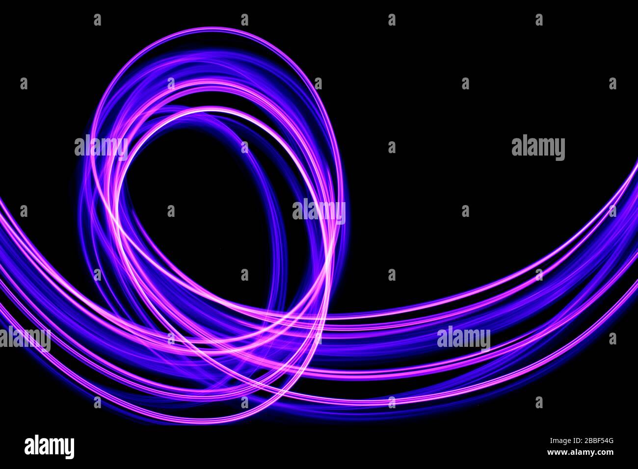 Long exposure photograph of vibrant neon color in an abstract swirl ...