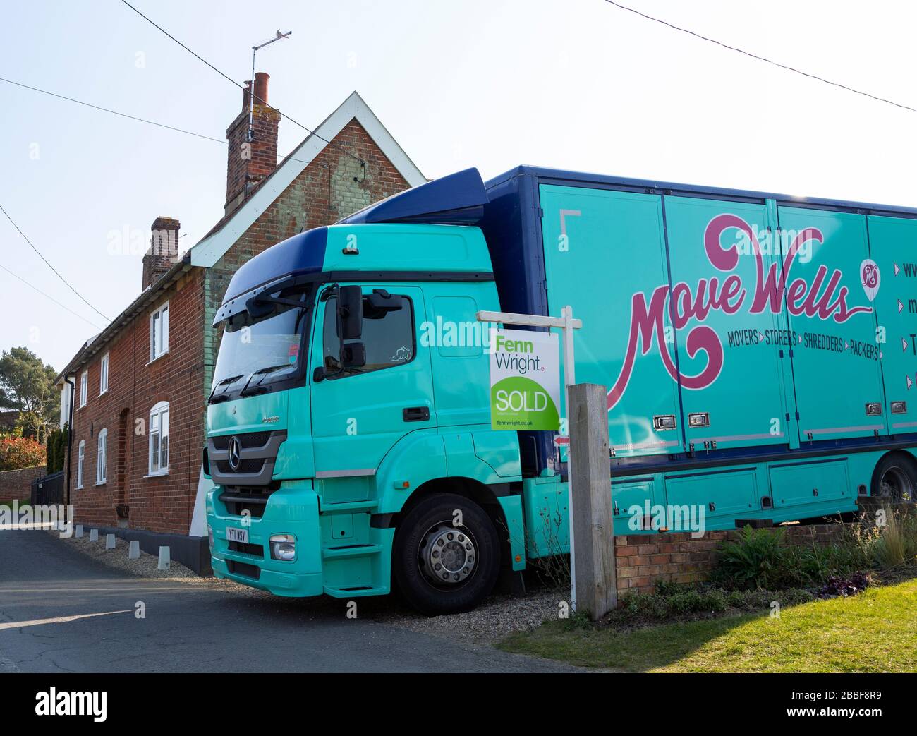 Removal van and estate agent sold sign next to house, moving in day ...