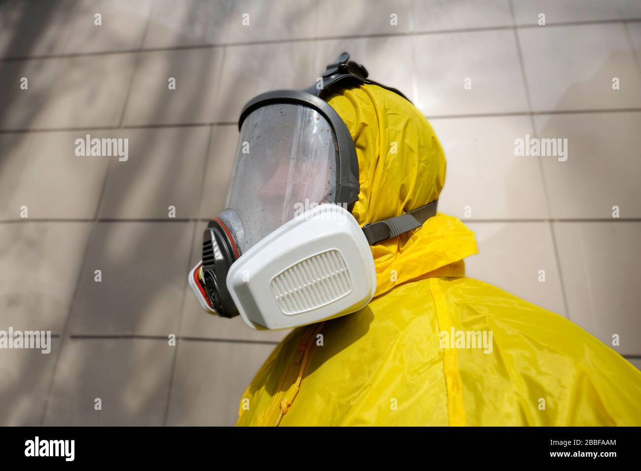 Paramedic wearing yellow protective costume and mask disinfecting ...
