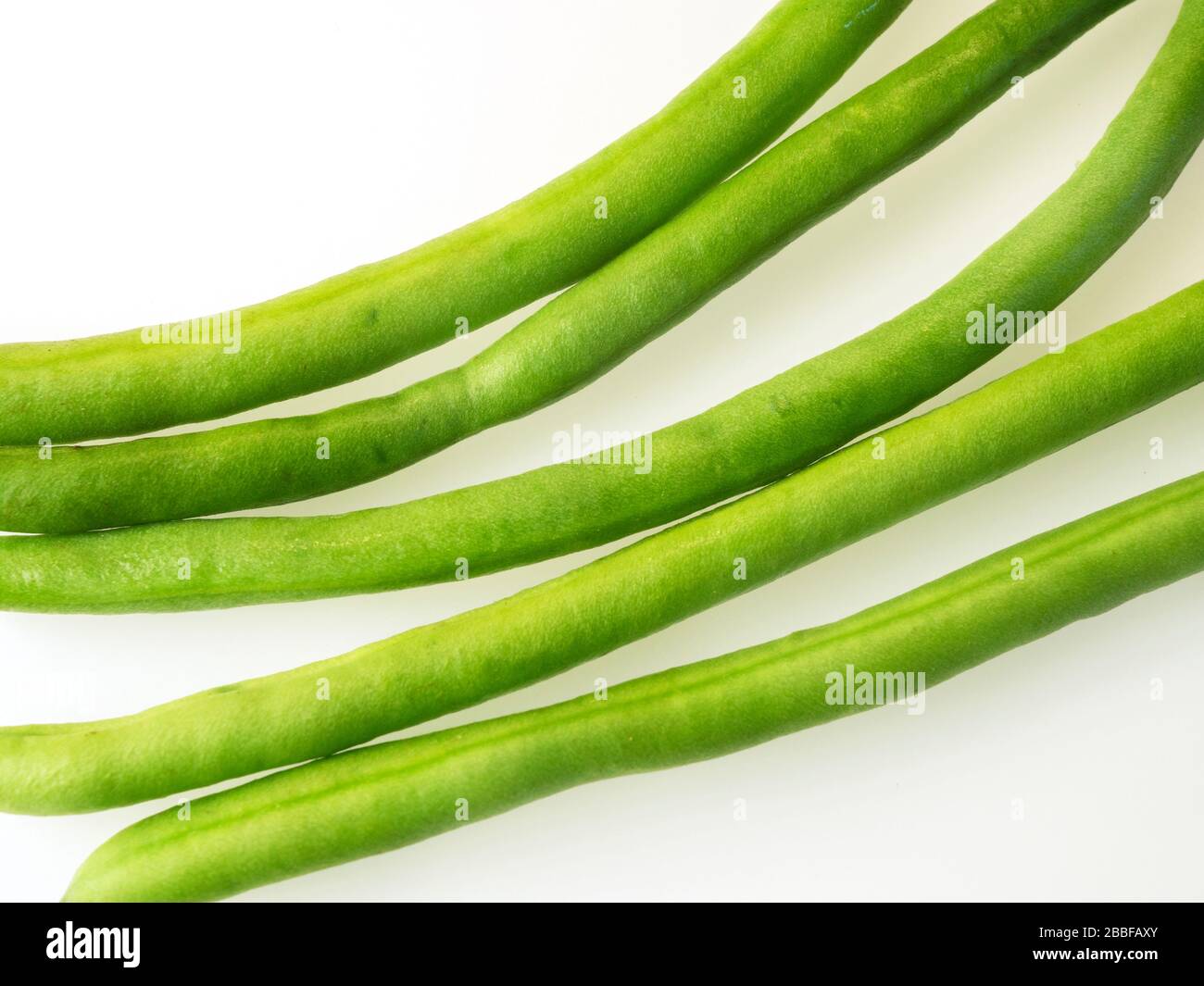 Five fine green beans on a white background Stock Photo - Alamy