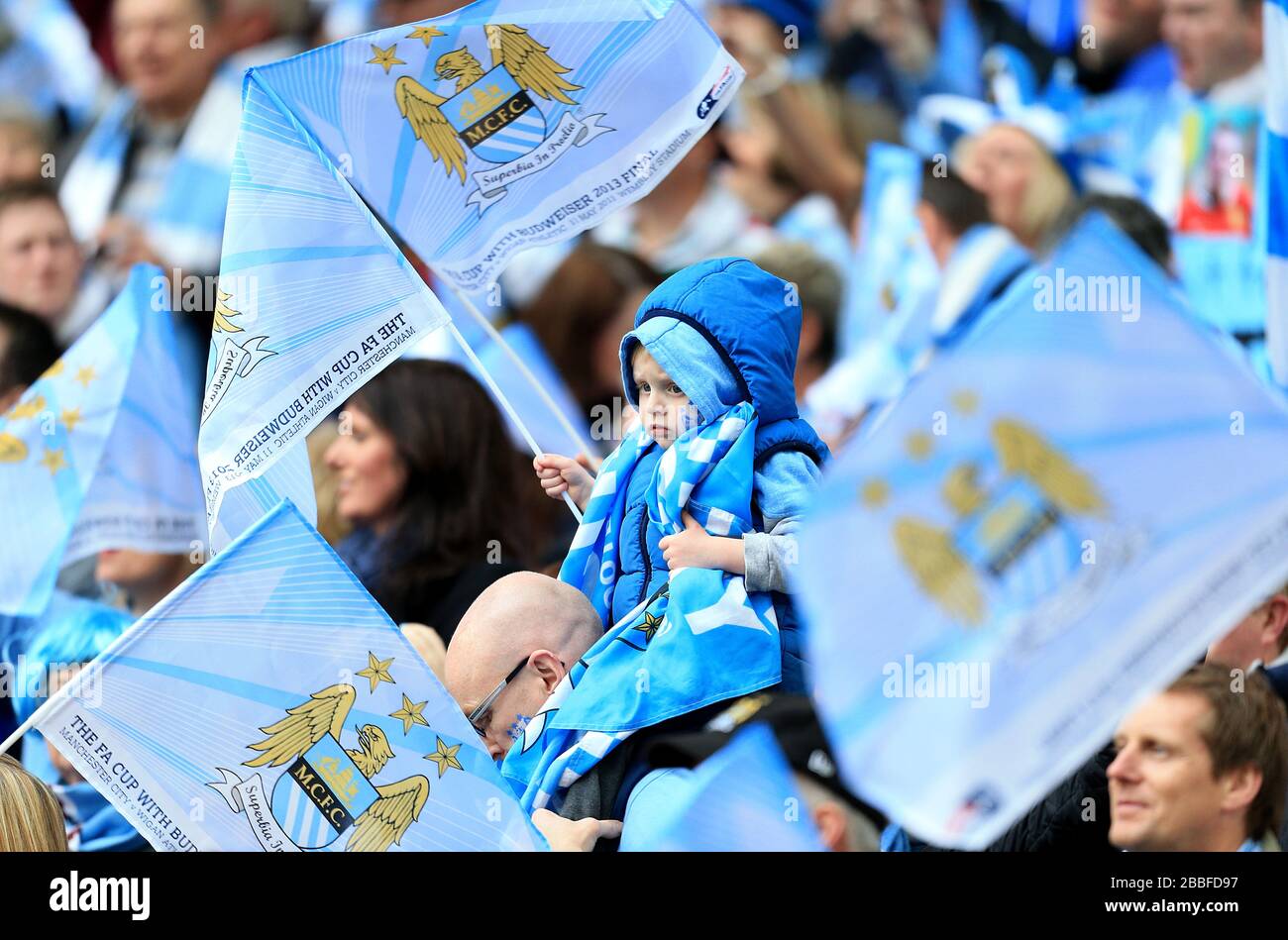 Manchester City fans wave flags in the stands Stock Photo - Alamy