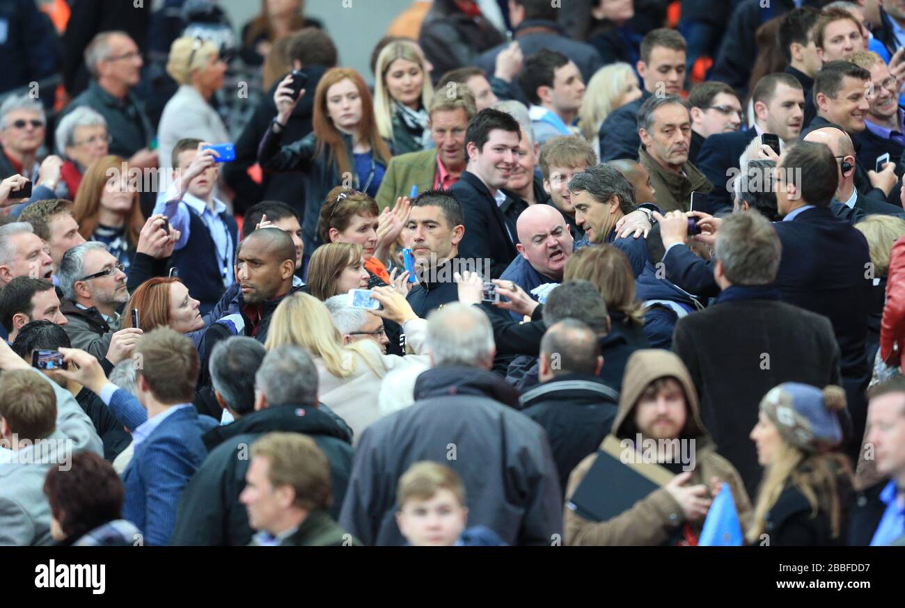 Manchester City manager Roberto Mancini (right) walks down the steps ...