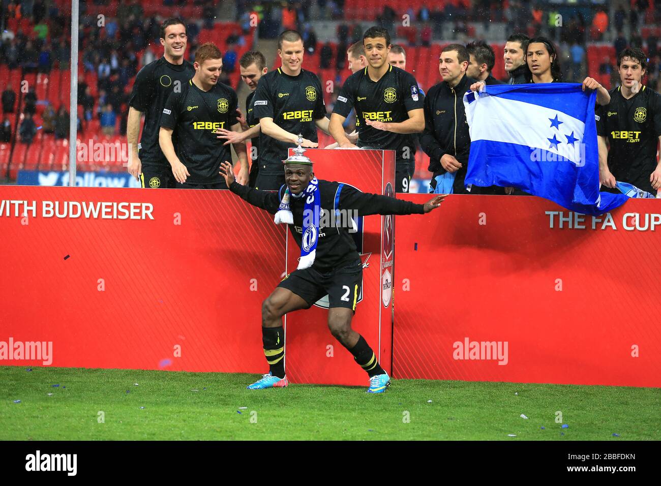 Wigan Athletic's Arouna Kone celebrates with the FA Cup lid on his head ...