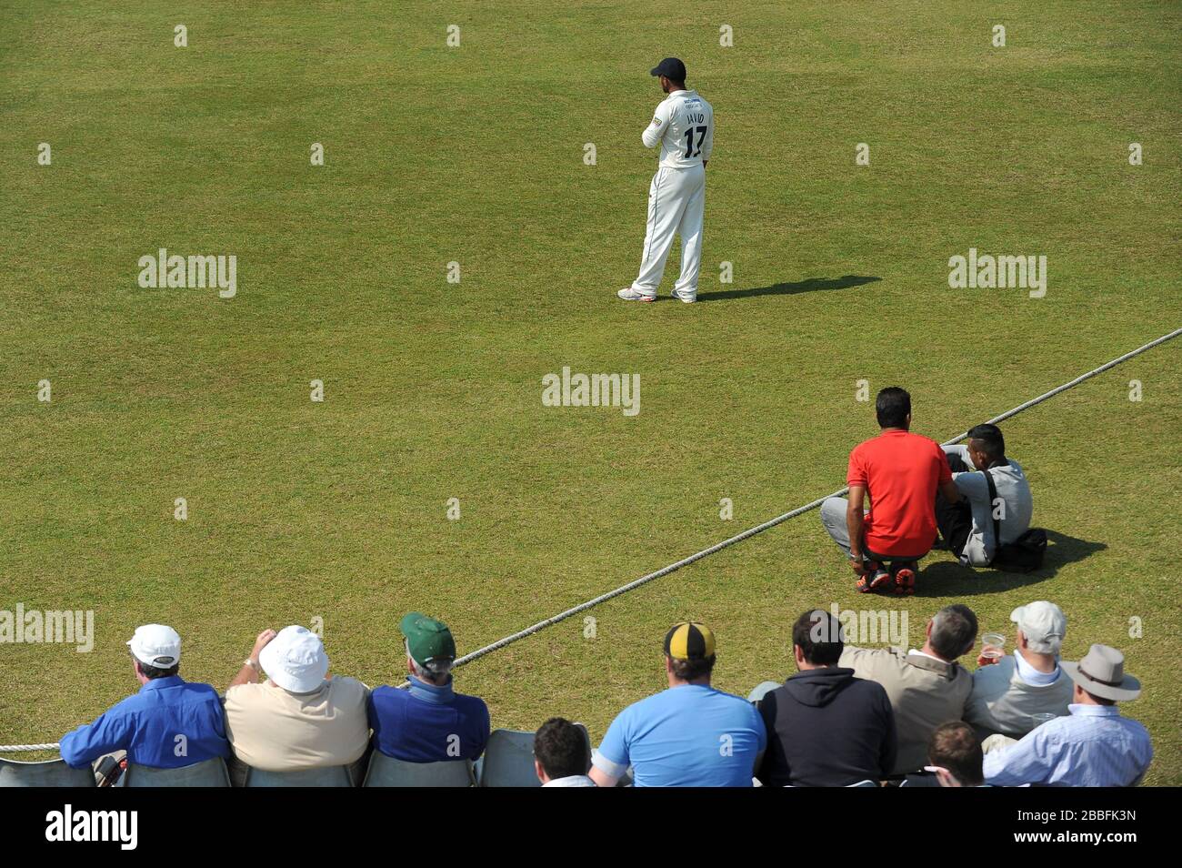 Fans keep an eye on the action as Warwickshire's Ateeq Javid fields on ...
