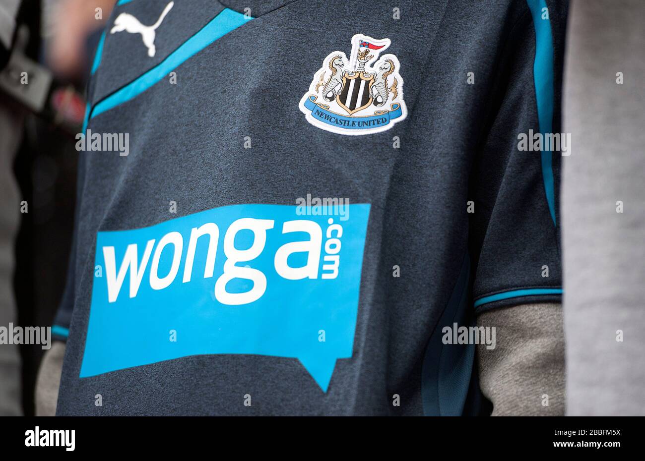 A Newcastle United fan wears a sweatshirt sponsored by Wonga Stock ...