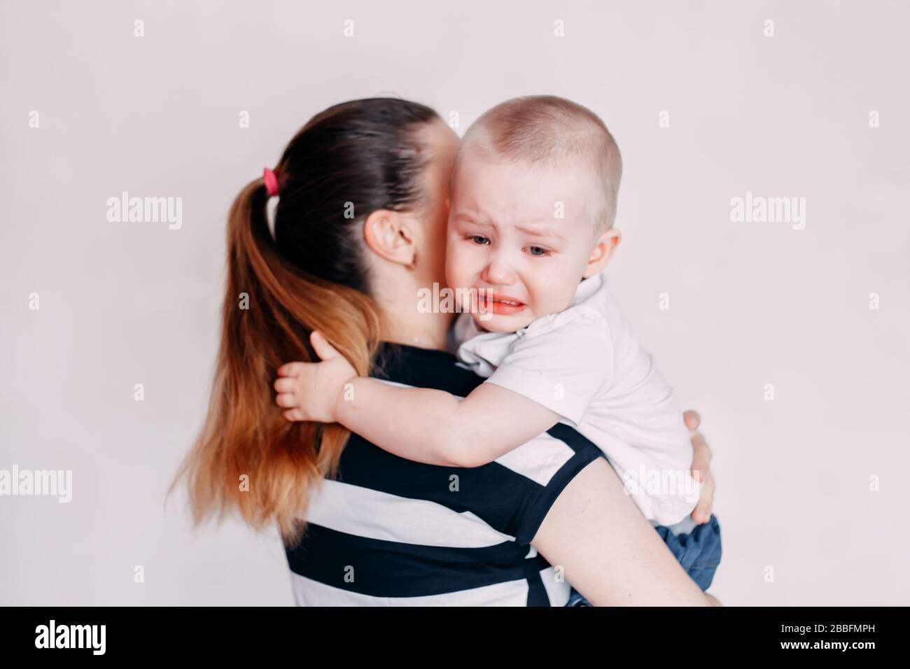 Crying toddler girl being consoled by her mother Stock Photo - Alamy