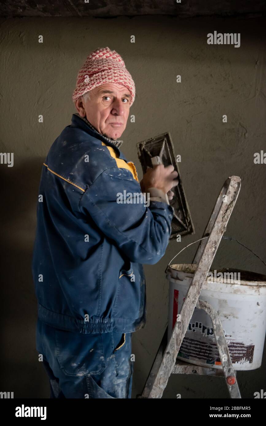 Construction worker plastering interior wall using cement plaster ...