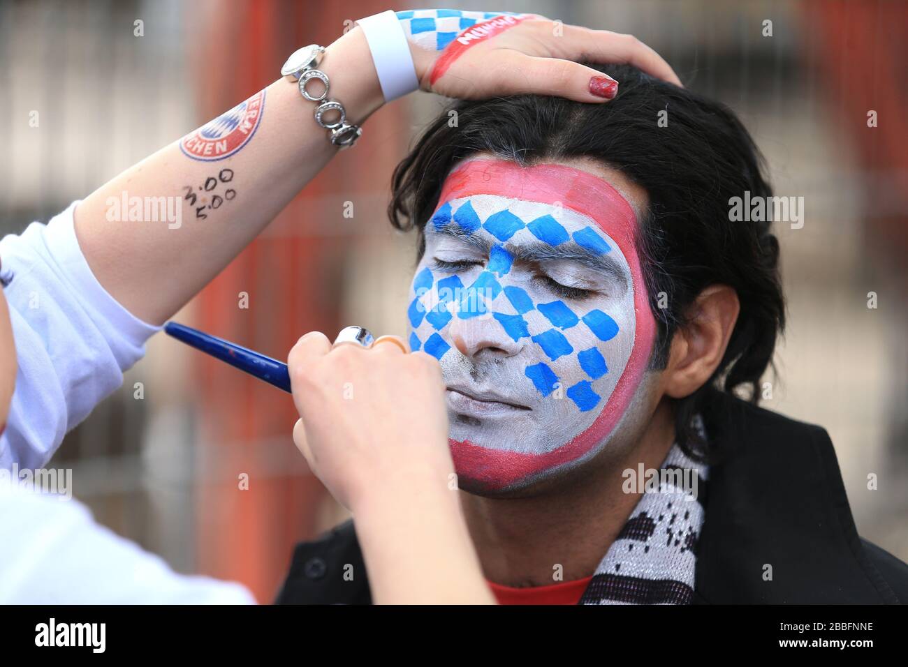 A Bayern Munich fan has his face painted outside Wembley Stadium Stock ...