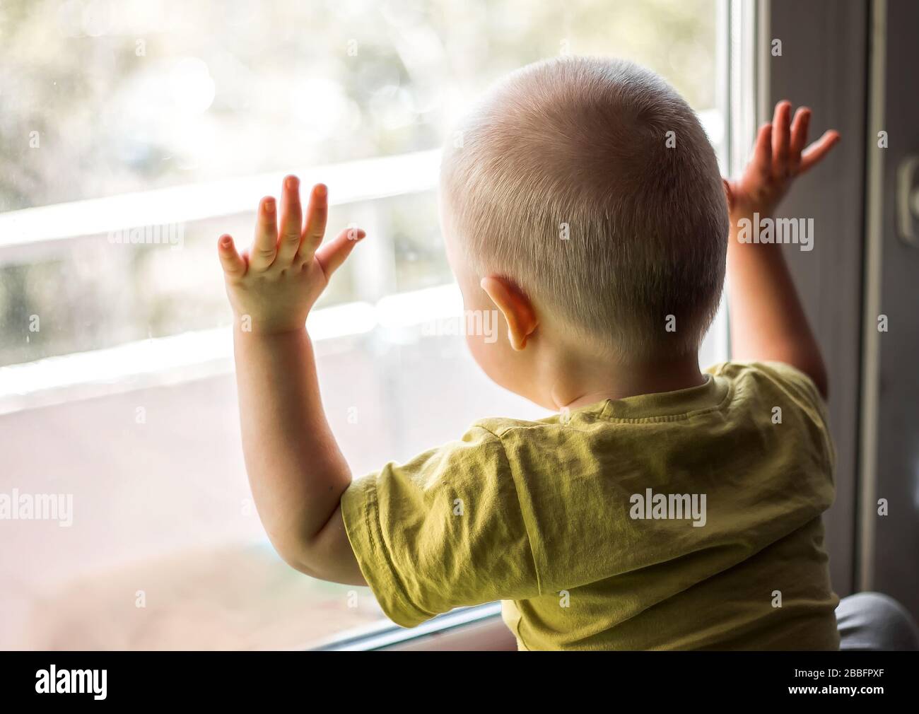 baby boy looking through window Stock Photo - Alamy