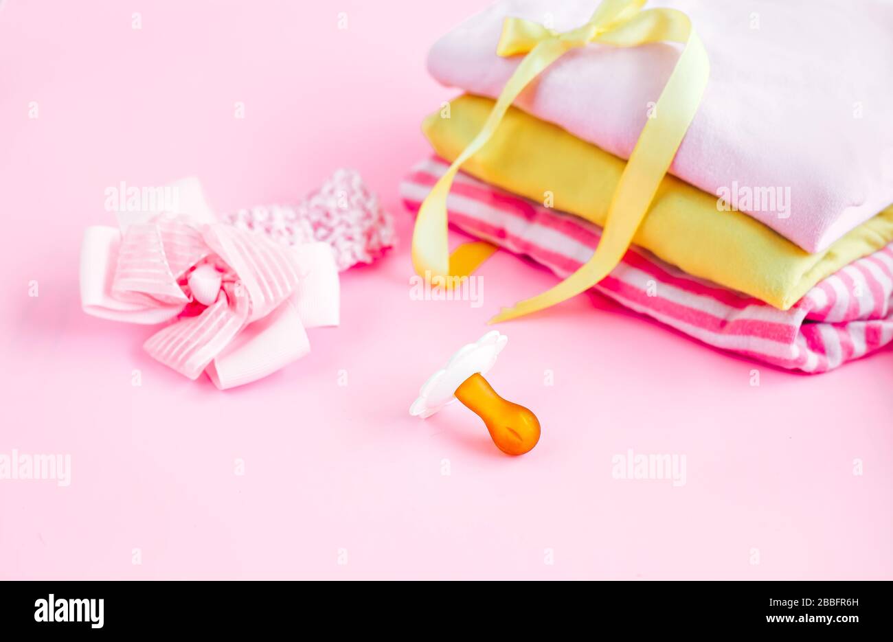 newborn stuff, clothes and pacifier for baby girl on pink background ...