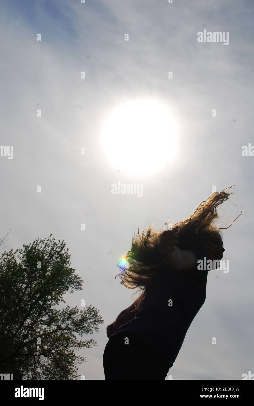A silhouette of a woman twirling in the sun Stock Photo - Alamy