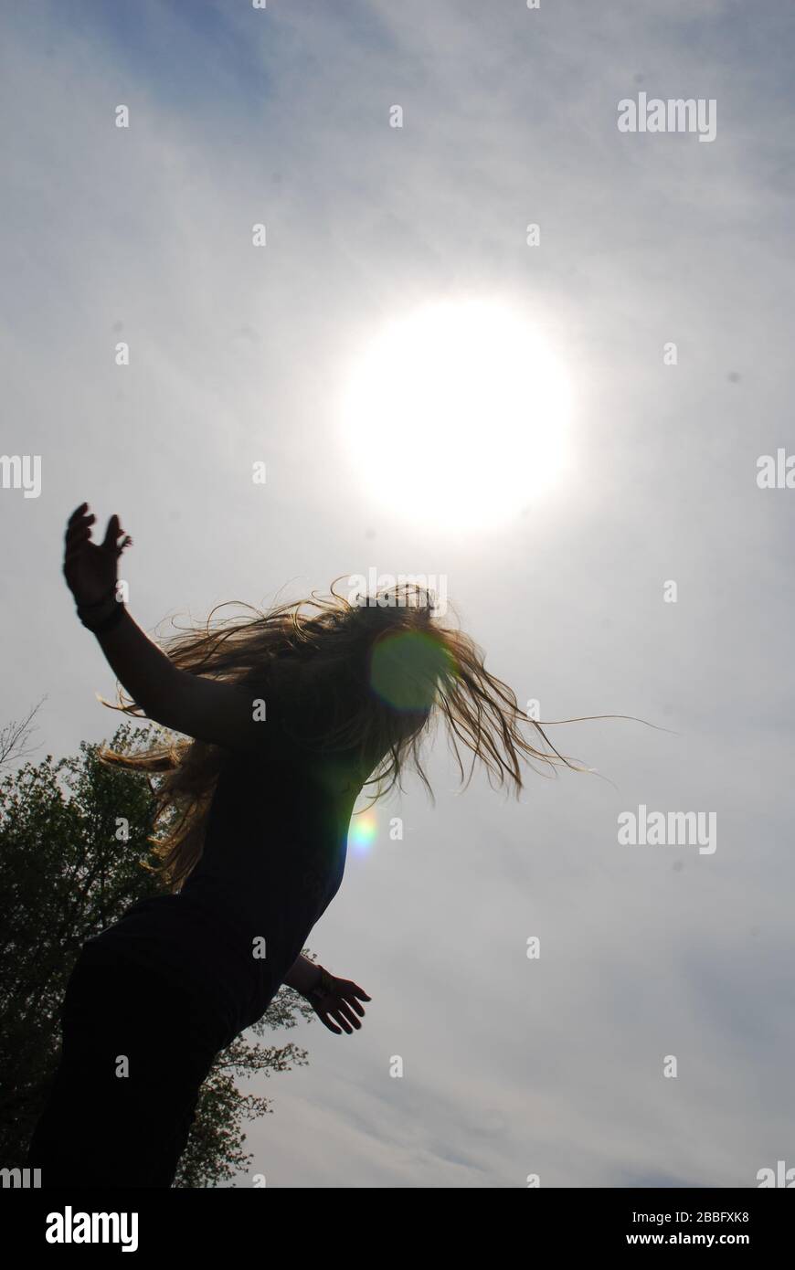 A silhouette of a woman twirling in the sun Stock Photo - Alamy