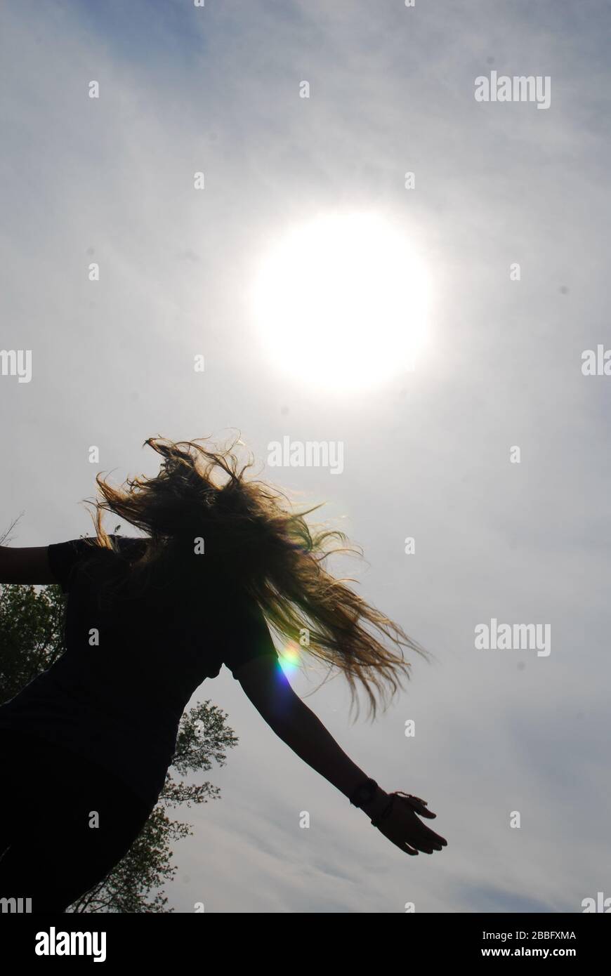 A silhouette of a woman twirling in the sun Stock Photo - Alamy