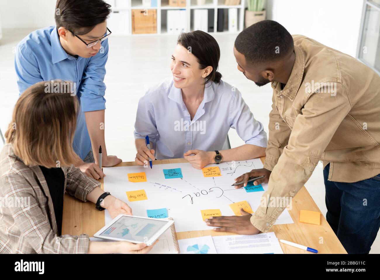 Team members of startup project exchanging creative ideas while ...