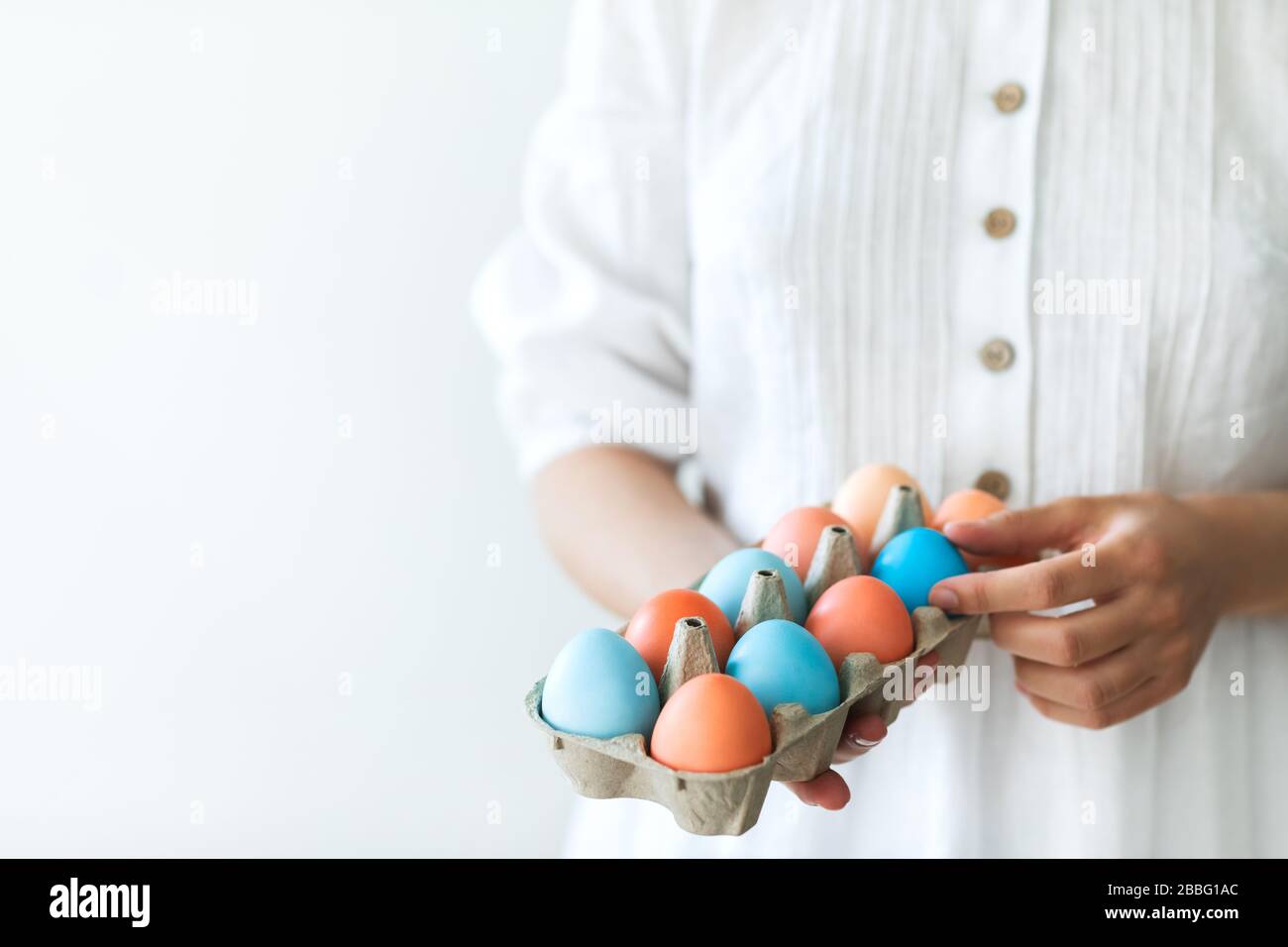 Woman in rustic linen white dress holding carton box with painted red ...