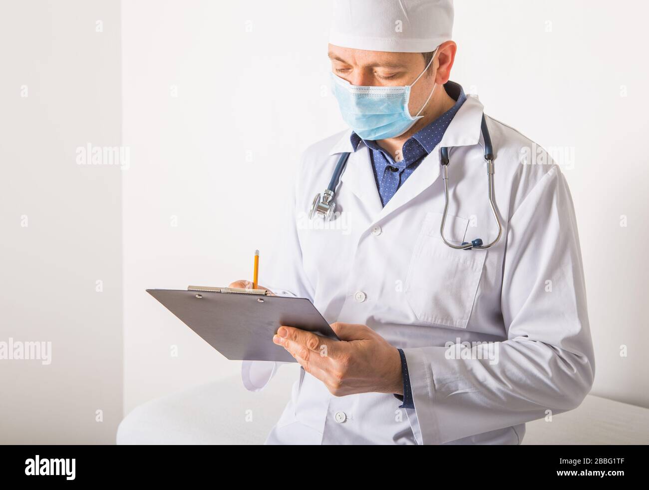 Doctor in mask with stethoscope writing RX prescription on clipboard on ...