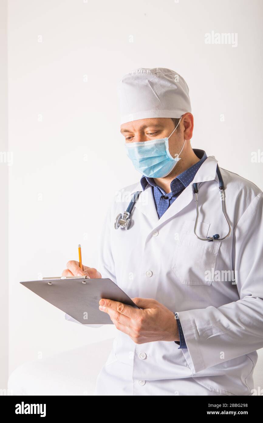 Doctor with stethoscope writing RX prescription on clipboard on white ...