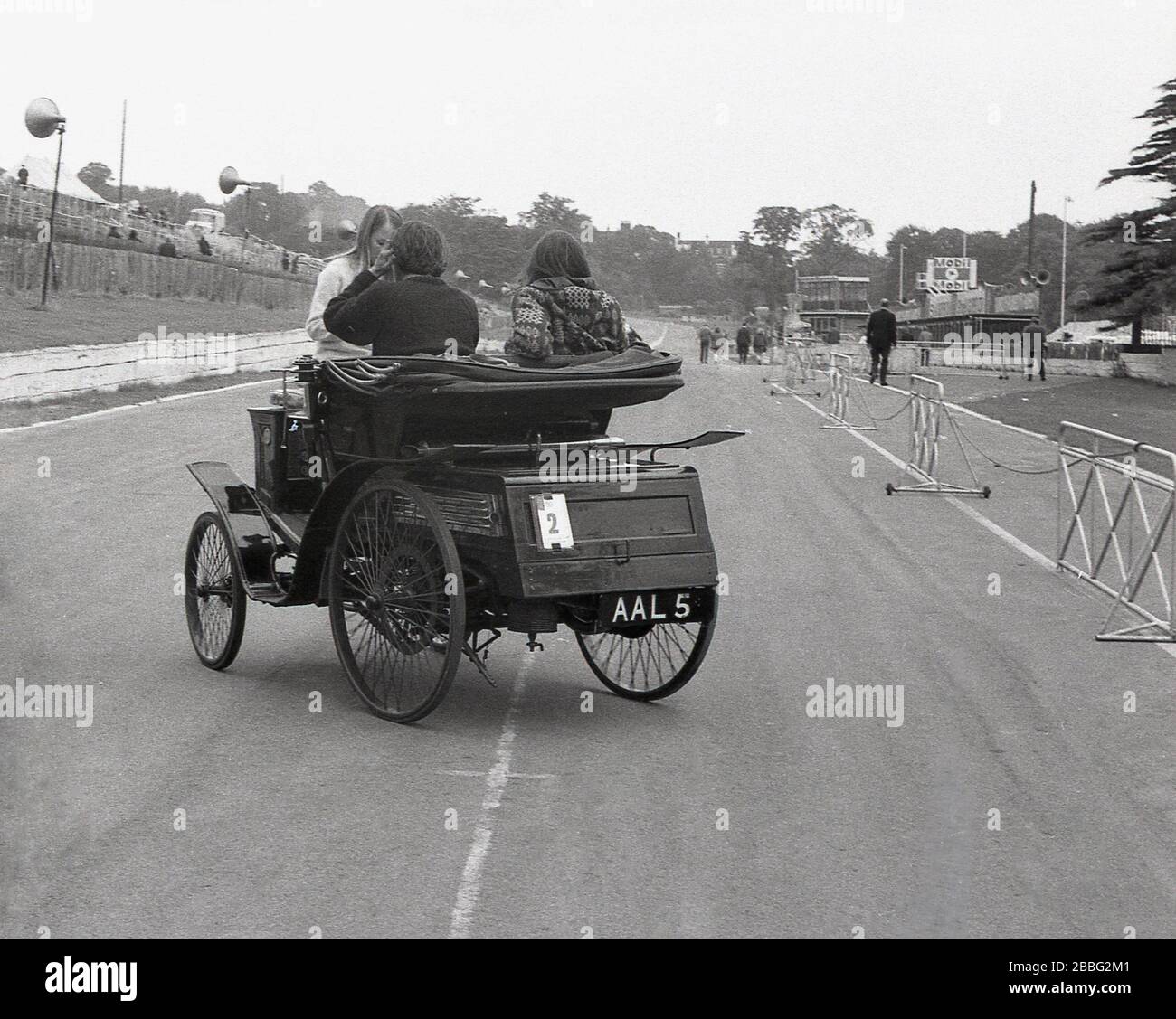 1970s, two people sitting in an open top veteran car on the historic ...