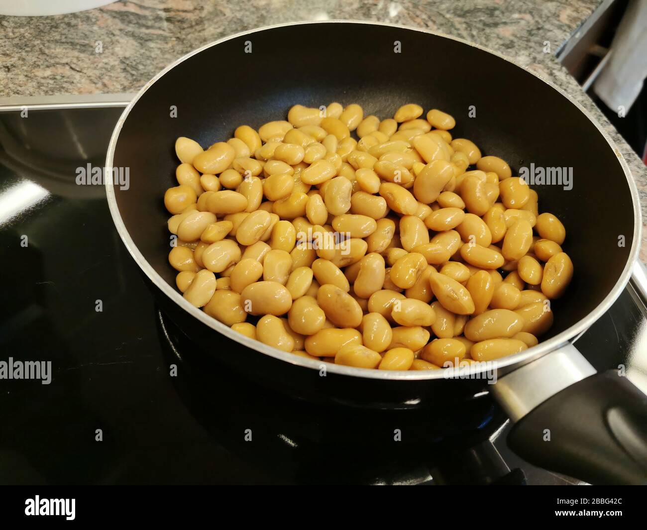 Cooking - Yellow beans are fried in a frying pan Stock Photo - Alamy