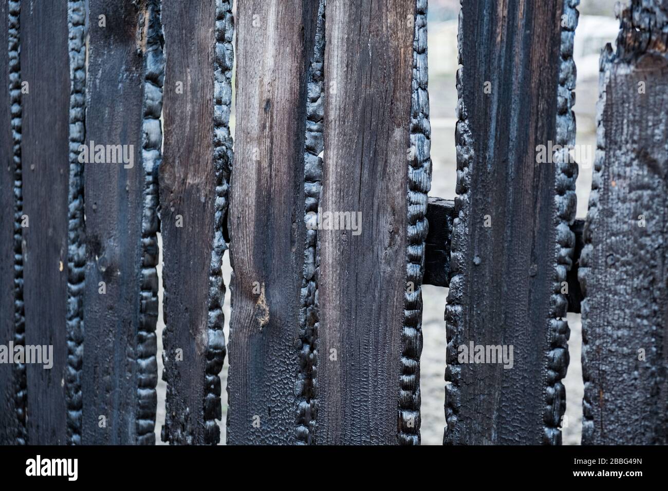 Burnt fence boards after a fire in a private house. The consequences of ...