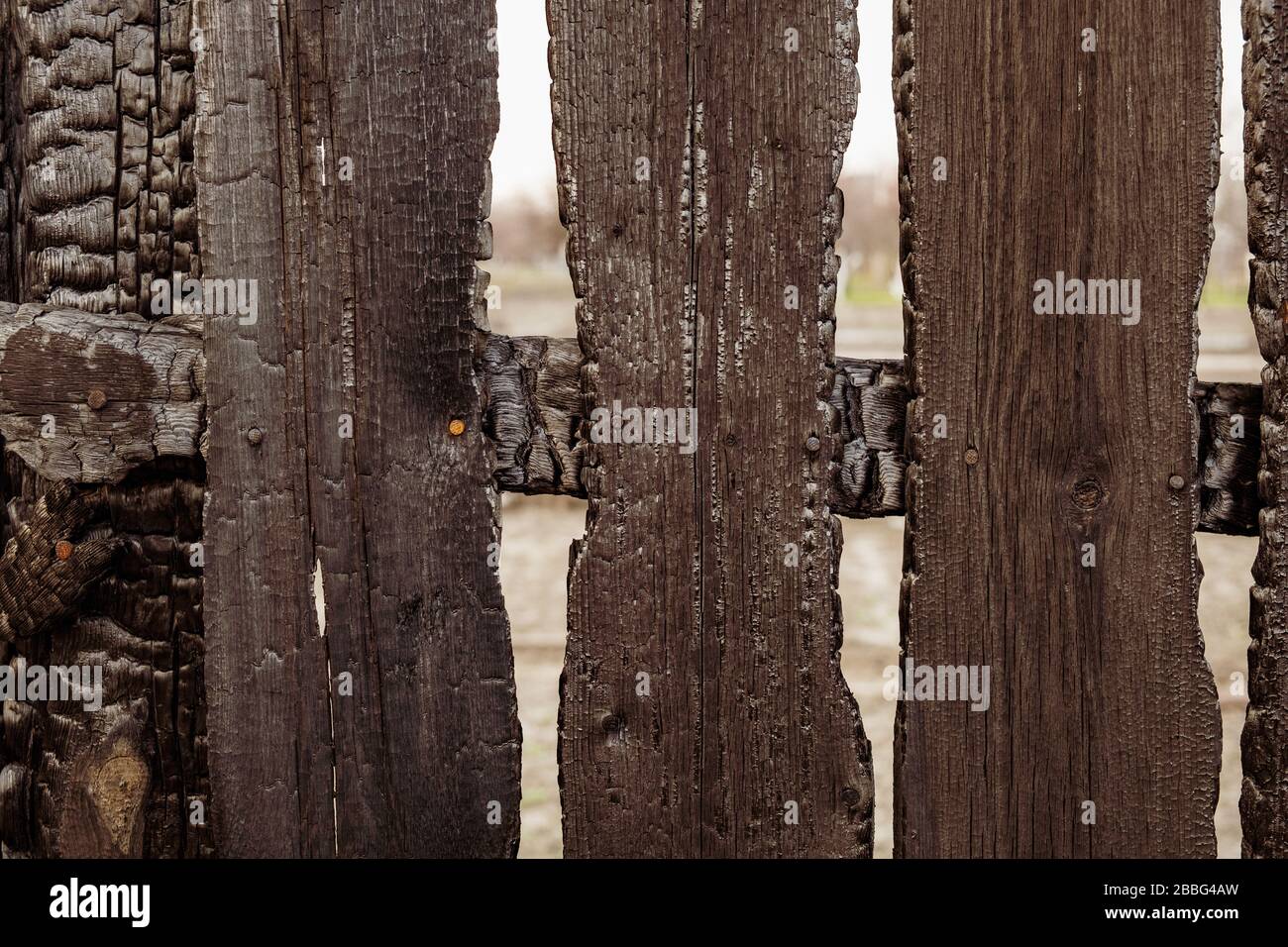 Burnt fence boards after a fire in a private house. The consequences of ...