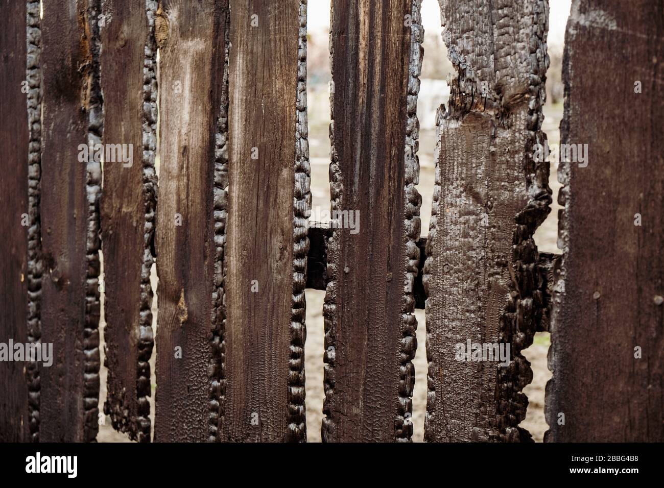 Burnt fence boards after a fire in a private house. The consequences of ...