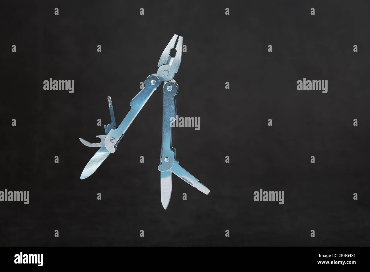 Multi-functional tool flying on a black background. The concept of an ...