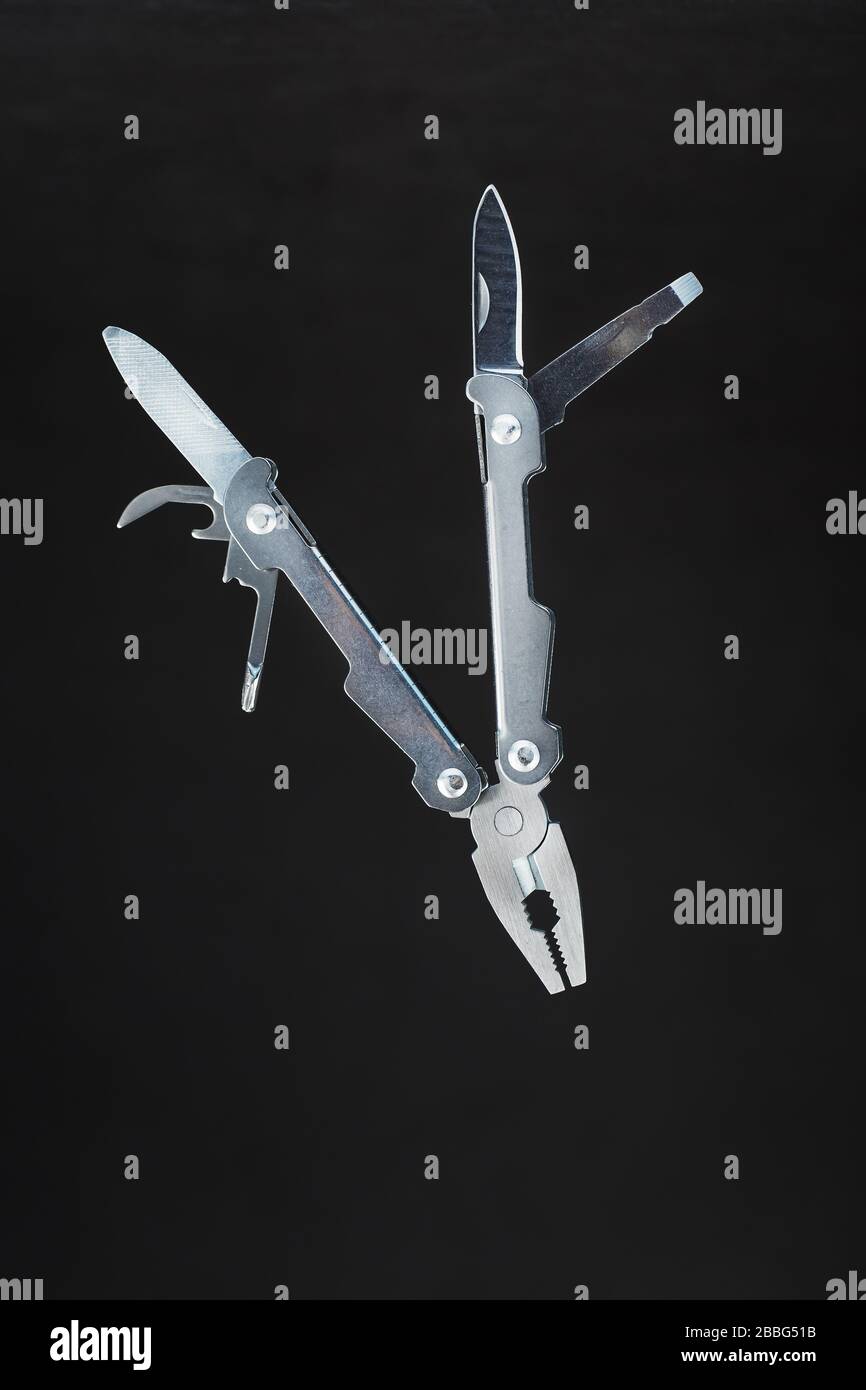 Multi-functional tool flying on a black background. The concept of an ...