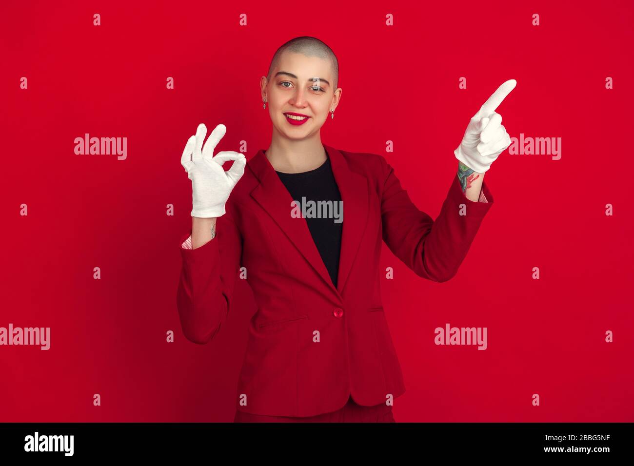 Pointing, showing. Portrait of young caucasian bald woman isolated on ...