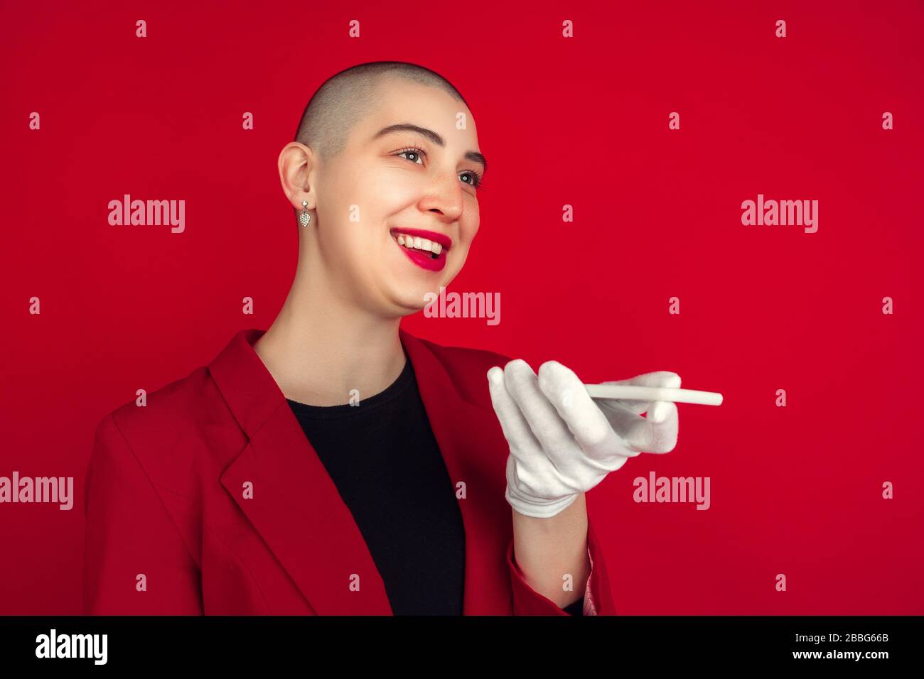 Recording voice Portrait of young caucasian bald woman isolated on red ...