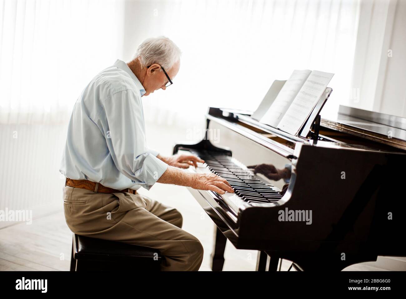 Happy senior man playing a grand piano Stock Photo - Alamy