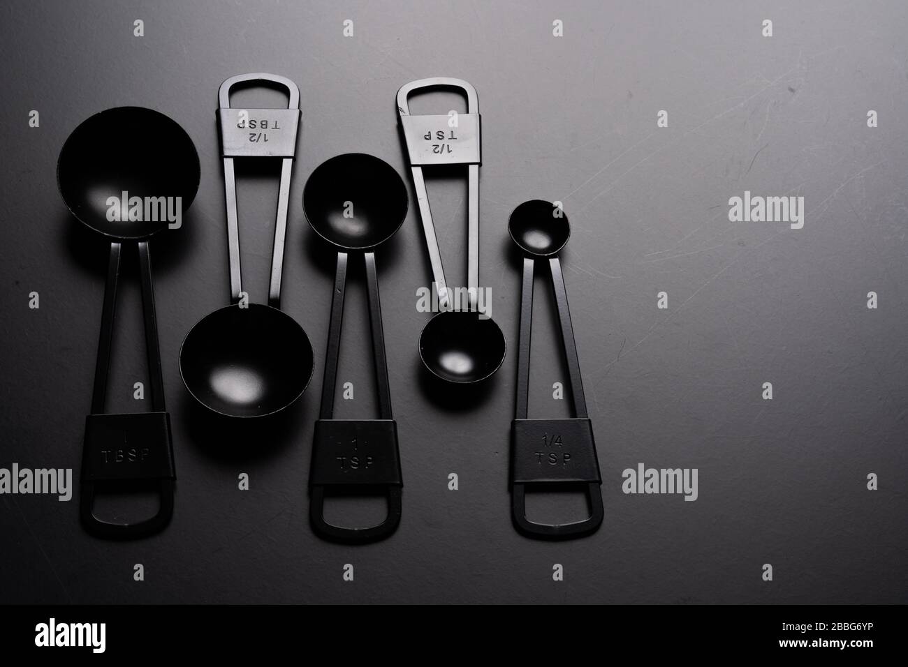A set of black measuring spoon on black background Stock Photo - Alamy