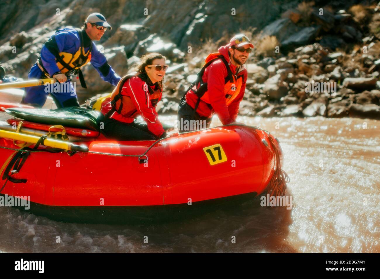 Group of friends having fun while white water rafting together through ... Group of friends having fun while white water rafting together through ...