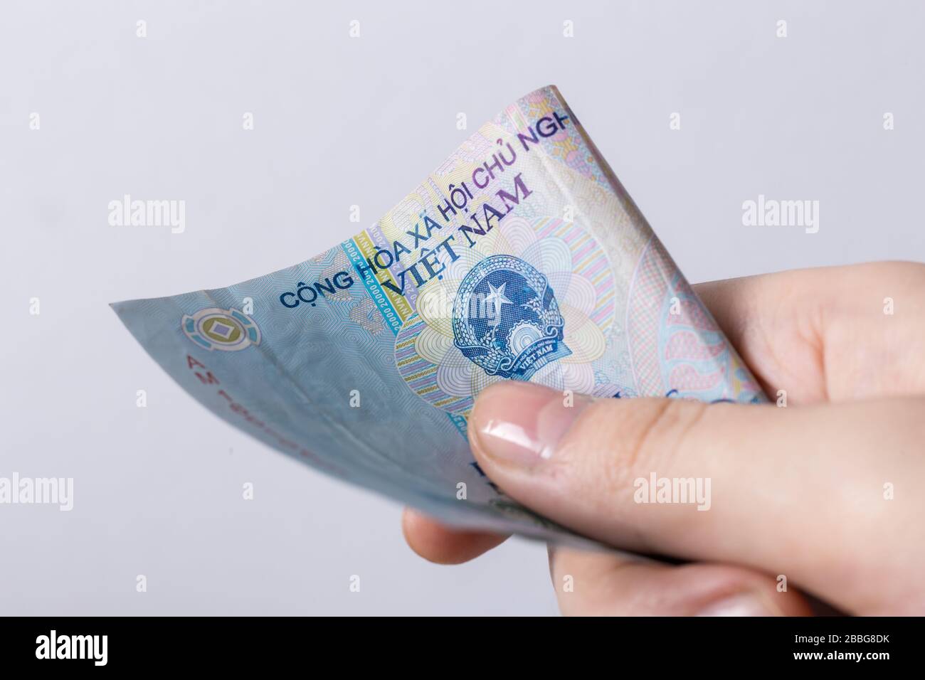 Hand holding cash banknote of Vietnamese dong VND paying bills, payment ...