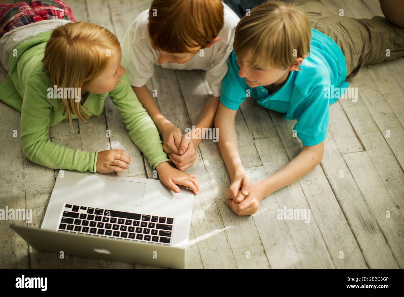 Happy siblings playing with a laptop computer Stock Photo - Alamy